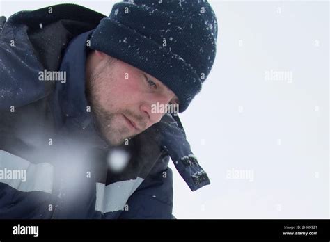 Portrait Of An Assembler Worker In A Jacket With A Hood At The Construction Of An Ice Camp Stock