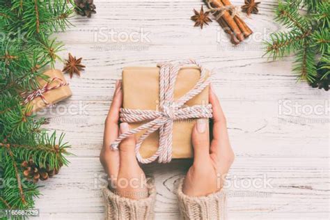 흰색 나무 테이블 배경에 재활용 종이에 수제 선물 상자를 들고 여성의 손 크리스마스 준비 개념 선물 포장 배경 격 조 12월에 대한 스톡 사진 및 기타 이미지 Istock