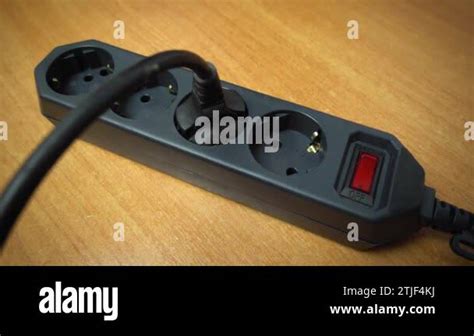 Insert Plug Into Extension Cord Socket By Pressing Red Push Button Switch With Your Finger