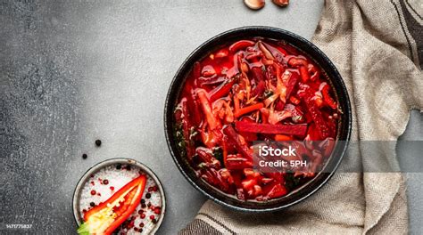 사탕무 채소 허브를 곁들인 수제 빨간 양배추 수프 회색 주방 테이블 배경에 접시에 담긴 러시아 보르슈트 상단 보기 복사 공간 비건 채식주의 자 건강 식단 현지 음식 감자