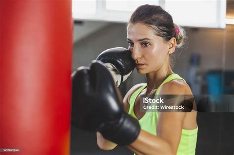 젊은 여성은 체육관에서 훈련하고 펀칭 백 앞에서 권투 글러브에서 권투 연습을합니다 건강한 생활방식에 대한 스톡 사진 및 기타 이미지 건강한 생활방식 권투 선수 권투