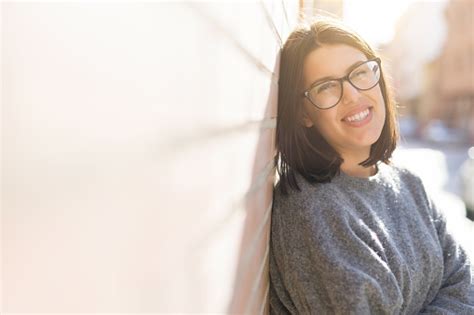 아름 다운 젊은 여 자가 도시에서 벽돌 벽 캐주얼 예쁜 여자에 쾌활 하 게 기대어 웃는 안경을 쓰고 갈색 머리에 대한 스톡 사진 및 기타 이미지 Istock