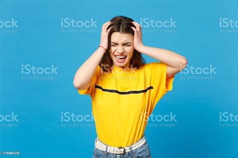 스튜디오에서 파란색 벽 배경에 고립 된 머리에 손을 넣어 눈을 감고 생생한 캐주얼 복장에 비명 젊은 여자 좌절의 초상화 사람들 라이프 스타일 개념입니다 복사 공간을 모의