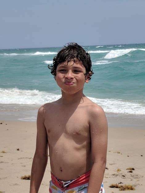Portrait Of Shirtless Boy Standing At Beach Premium Photo