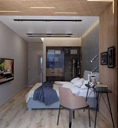 A Bedroom With A Bed Chair And Television On The Wall Next To Each Other