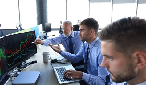 Premium Photo Group Of Modern Business Men In Formalwear Analyzing Stock Market Data While