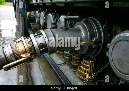 Fuel Tanker Unloading At A Service Station With Two Hoses Connected And Another For Gas