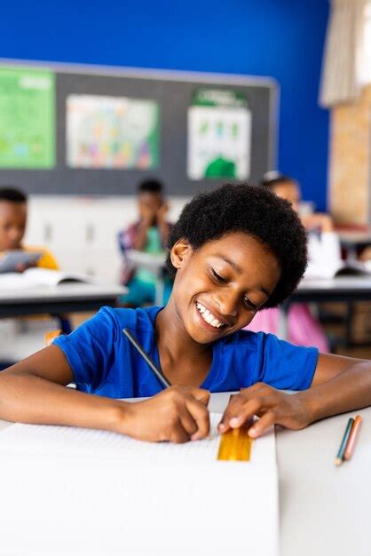 Feliz Niño De Escuela Primaria Afroamericano Escribiendo En Un Cuaderno