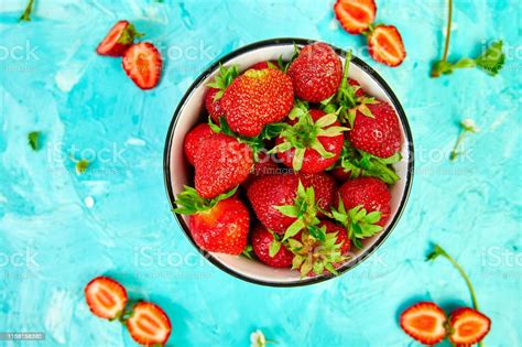 파란 테이블에 잘 익은 빨간 딸기 빨간 그릇에 딸기 신선한 딸기 아름다운 딸기 다이어트 음식 건강하고 비건 맨 위 보기 플랫