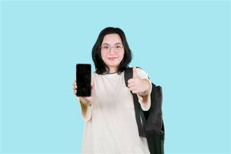 Симпатичная азиатка показывает экран мобильного телефона и показывает ...