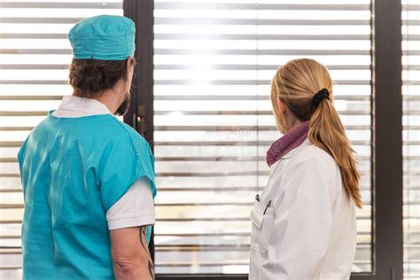 Twee Artsen Of Verpleegsters Voor Een Venster Stock Afbeelding Image Of Team Zonneblinden