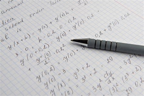 Premium Photo Paper With Written Mathematical Calculations And Pen