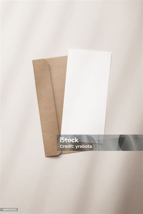 백지 카드 모형과 베이지색 배경에 공예 봉투 하얀 빈 편지나 초대장 햇빛 그림자 미니멀한 모던 라이프스타일 수직 플랫 레이 평면도 복사 공간 0명에 대한 스톡 사진 및 기타