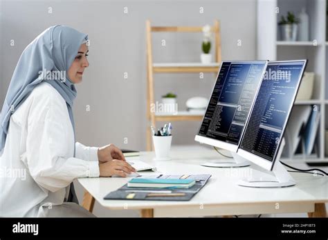 programmer woman wearing hijab working coding business software stock