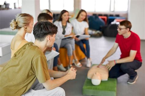 Cpr Class With Male Instructor Speaking And Demonstrating First Aid