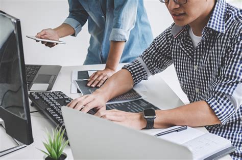 협력 웹 사이트에서 작업 하는 프로그래머는 소프트웨어 개발 회사에서 데스크탑 컴퓨터에 프로젝트 코드를 작성 하 고 입력 데이터 코드 기술 개발에 대한 스톡 사진 및 기타