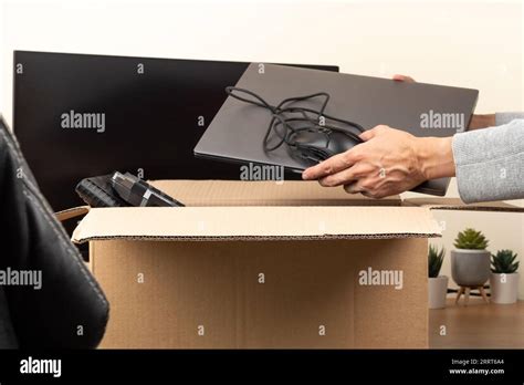 Woman Hands Put Old Laptop Computer In Cardboard Box With Old Used Tech Gadget Devices For