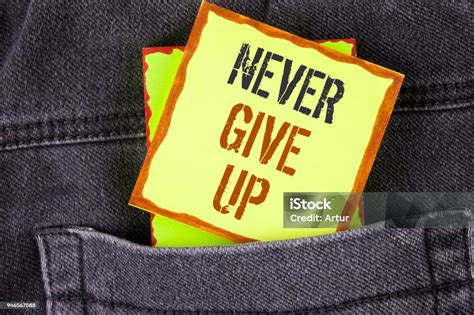 필기 텍스트 작성 절대 포기입니다 개념 지속 될 의미 자신을 동기 부여 성공 결코 다시 청바지 배경에 배치 하는 스티커 메모 용지에 작성 하는 모습 격려에 대한 스톡 사진