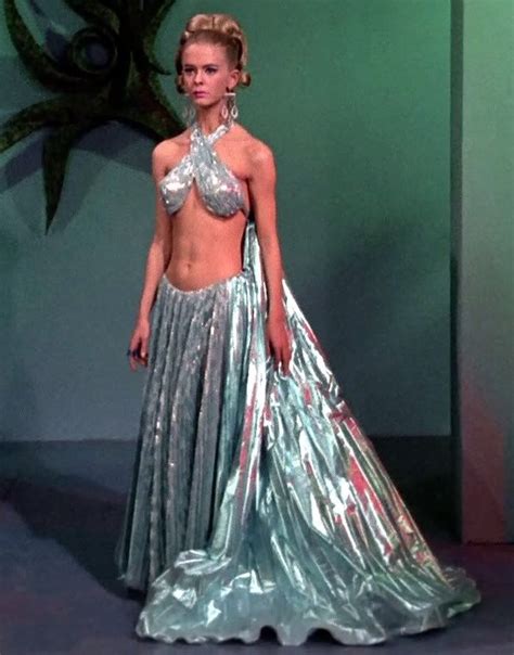 A Woman In A Silver Dress Walking Down A Runway