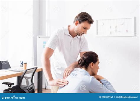 Masajista Mirando A La Mujer De La Morena Mientras Imagen De Archivo Imagen De Equipo