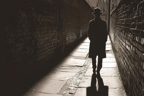 Premium Photo A Shadowy Figure Stands Alone In A Dimly Lit Alleyway Casting Long Shadows Into