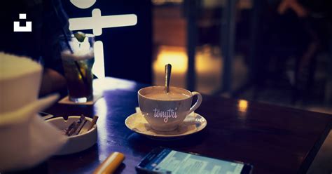 갈색 나무 커피 테이블에 찻잔 옆에 검은 안 드 로이드 스마트 폰 사진 Unsplash의 무료 베트남 이미지