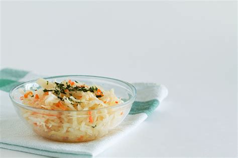 흰색 배경에 유리 접시에 허브와 오렌지 당근과 수제 소금에 절인 양배추 테이블에 직물유리 그릇에 절인 양배추 복사 공간을