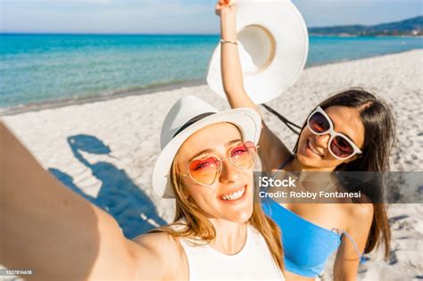 열대 해변 리조트에서 여름 휴가를 즐기는 자화상을 찍는 흰색 모자를 쓴 두 명의 아름다운 소녀 Pov 의 젊은 금발의 여자 사용