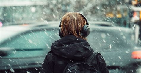 눈 덮인 도시 거리를 걷는 젊은이 · 무료 스톡 사진