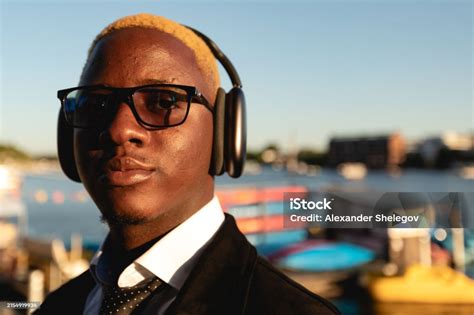 패션 흑인 남자 야외에서 노란 머리를 가진 유색인종의 사진 거리의 남성 초상화입니다 실제 사람들과 함께하는 라이프스타일 사진 음악을 듣기 위해 무선 헤드폰을 듣는 사람