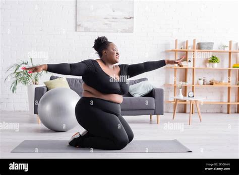 Happy African American Plus Size Woman In Sportswear With Outstretched