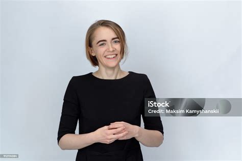 넓은 미소와 흰색 배경에 고립 되 고 그녀의 손 앞 연결 좁혀 눈을 가진 젊은 여자의 스튜디오 초상화 갈색 머리에 대한 스톡