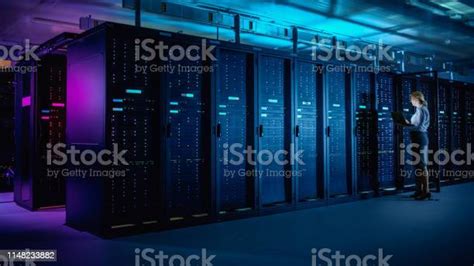 데이터 센터 랩톱에서 유지 관리 프로그램을 실행 하는 It 기술자는 운영 서버 랙 최적 기능을 제어 합니다 네온 불빛에 있는 현대 하이테크 통신 운영 데이터 센터 데이터