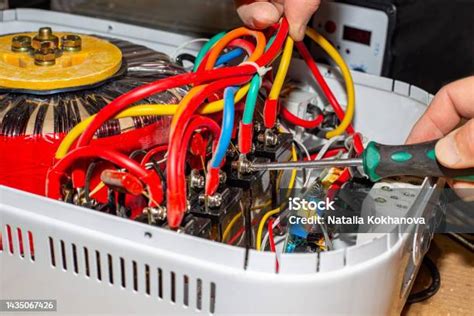 전압 안정기 수리 전기 기술자가 안정 장치의 전원 와이어를 푸십시오 컴퓨터 전원공급장치에 대한 스톡 사진 및 기타 이미지