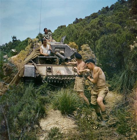 Two Men Are Working On A Tank While Another Man Looks At The Camera From Behind