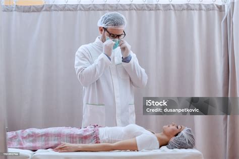 흰색 유니폼에 젊은 백인 의사와 수술 전에 여성 환자에 대 한 보호 마스크와 머리 그물 검사 Friendly Match에 대한