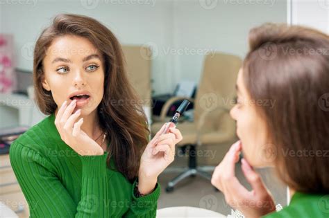 Woman Applying Gloss To The Lips Stock Photo At Vecteezy