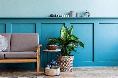 갈색 나무 소파 식물 커피 테이블과 우아한 개인 액세서리와 아파트에서 거실의 현대적인 인테리어 세련된 홈 장식 선반녹색 나무