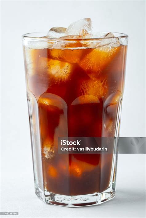 커피 원두를 붓고 크림이 있는 키가 큰 유리에 아이스 커피를 넣습니다 가벼운 배경에 차가운 여름 음료 0명에 대한 스톡 사진 및