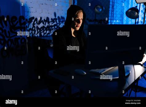 medium shot portrait of hidden hacker man wearing sweatshirt with hood