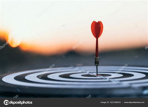 Close Red Dart Arrow Hitting Target Center Dartboard Sunset Background