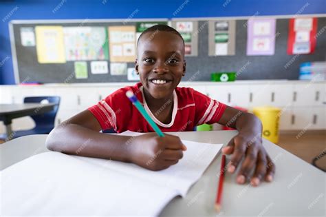 Portrait Dun Garçon Afro Américain Souriant Assis Sur Son Bureau Dans La Classe à Lécole