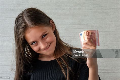 사람 개념 회색 배경 위에 10 유로 돈 지폐를 들고 풀오버를 입은 미소 짓는 십 대 소녀 10에 대한 스톡 사진 및 기타 이미지 Istock