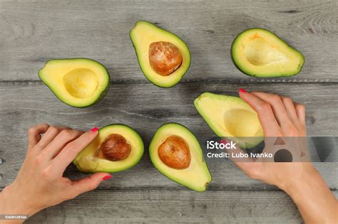 탁상 보기 여자 손에 빨간 손톱 절반 아보카도 들고 더 반 회색 나무 책상에 주위 씨와 그들 중 일부 건강한 생활방식에 대한 스톡 사진 및 기타 이미지 Istock