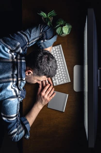 Um Homem Dorme Deitado Na Frente De Um Computador Em Sua Mesa De