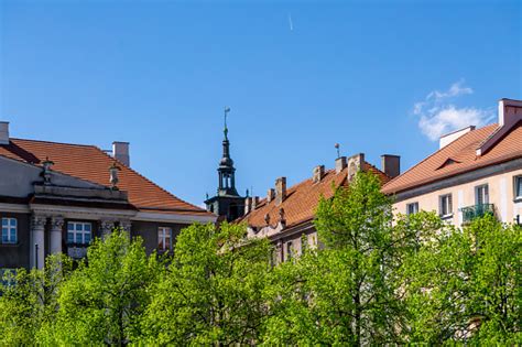 푸른 하늘 아래 무성한 녹색 나무로 둘러싸인 빨간 지붕과 배경에 교회 탑이 있는 유서 깊은 연립 주택의 전망 봄 도시 풍경 0명에 대한 스톡 사진 및 기타 이미지 Istock