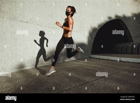 Female Athlete On Morning Running Workout Woman In Fitness Wear Wearing Face Mask Running