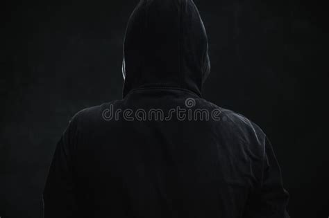 Unrecognizable Cyber Criminal Or Computer Hacker Wearing Black Hooded
