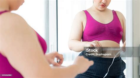 아시아 뚱뚱한 여성 테이프 신체 이미지 체중 감량 도전 피트니스 목표 플러스 사이즈 여성이 거울에서 배를 확인 건강한 라이프 스타일 다이어트 개념 자기 관리 및 25 29