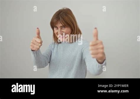 Joyful Middle Aged Woman In Sweater Stands Victorious Flashing Thumbs